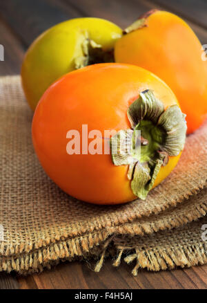 fresh natural kaki fruits on wooden table Stock Photo - Alamy