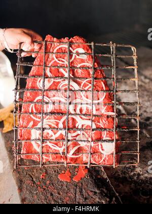 A cook prepares tikin xic, a whole fish that is rubbed with achiote ...