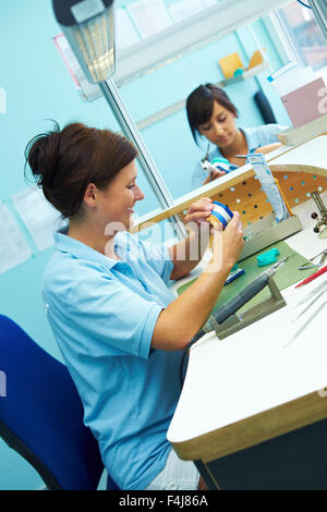 Two dental technicians working in a dental laboratory. 3D modeling of ...