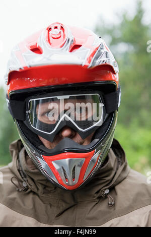 Close-up of man wearing crash helmet while standing on mountain against ...