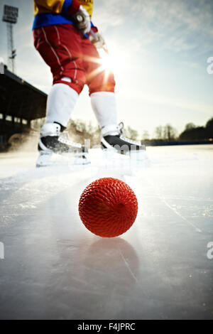 Bandy player standing by ball Stock Photo - Alamy