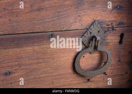 wrought iron handle at an open old garden gate with worn red color ...