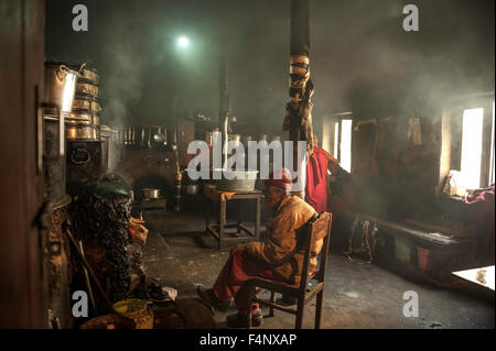 Old Monk is sitting in kitchen next to the fire Stock Photo - Alamy
