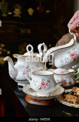 Making pouring a traditional British English cup of tea from a teapot ...