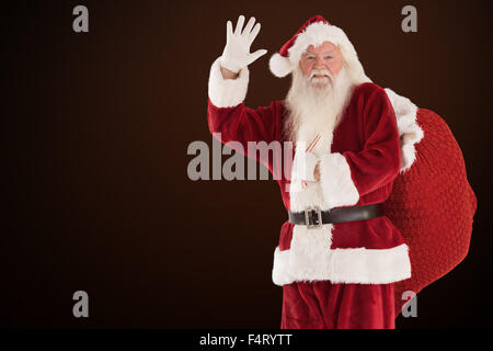 Composite image of santa waves to the camera Stock Photo - Alamy