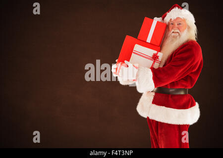 Composite image of santa carries a few presents Stock Photo - Alamy