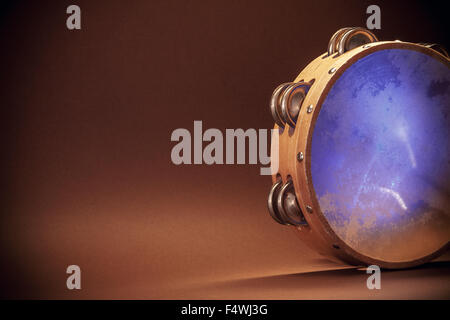 Old retro wooden tambourine on brown background, closeup view of ...