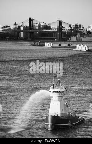 A Meredith C. Reinauer tugboat spraying water and sailing in the East ...