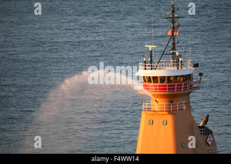 A Meredith C. Reinauer tugboat spraying water and sailing in the East ...