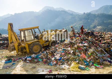 Rubbish dump workers. Children collecting recyclable items on rubbish ...
