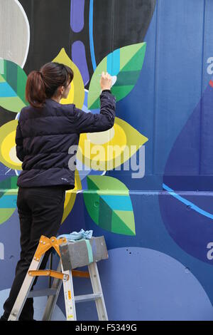 An artist paints a giant wall mural depicting a sumo wrestler on ...