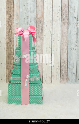 Stack of silver wrapped presents with a pink bow Stock Photo - Alamy