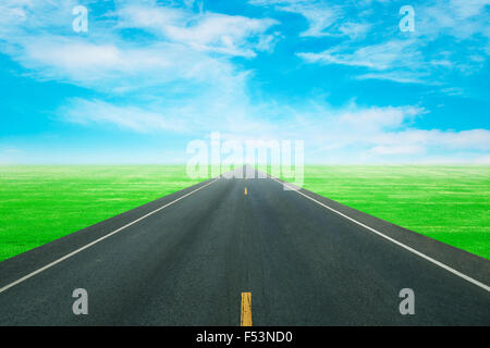 Asphalt road arrow with meadow and blue sky background Stock Photo - Alamy