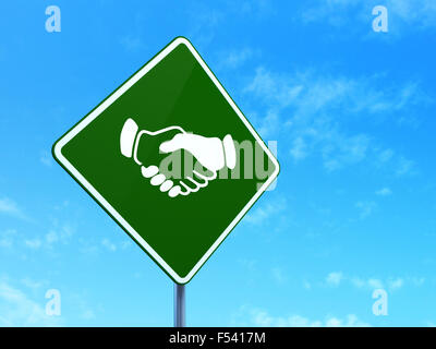 Finance concept: Handshake on road sign background Stock Photo - Alamy