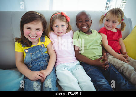Happy kids laughing while sitting down Stock Photo - Alamy
