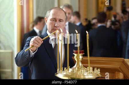 Russian President Vladimir Putin lights a candle at the St. Nicholas ...