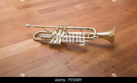 trumpet lying on wooden background Stock Photo - Alamy