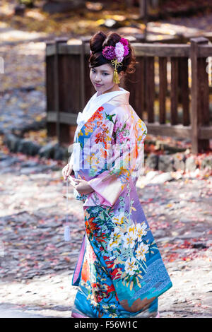 Side view of a pretty Japanese kimono woman standing isolated over ...