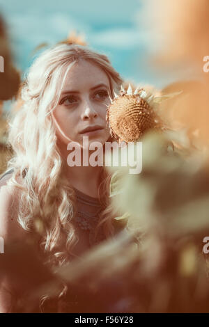 Beautiful young woman in sunflower field on summer day Stock Photo - Alamy