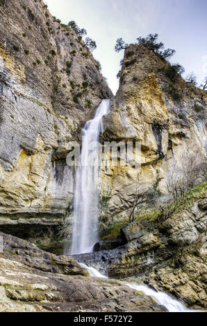 A beautiful view of a waterfall flowing down in a forest Stock Photo ...