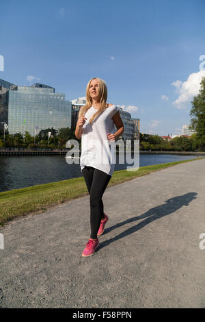 Young woman jogging near river Stock Photo - Alamy