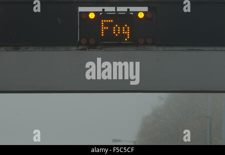 An illuminated motorway matrix sign which reads 'FOG SLOW DOWN' on the ...