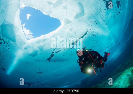 scuba diver under ice or icehole with safety robe, scuba icediving ...
