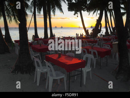 Outdoor restaurant tables on the beach at evening Stock Photo - Alamy