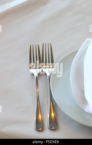 Two forks on a dinner table in a restaurant Stock Photo - Alamy