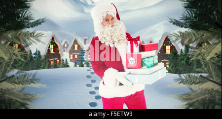 Composite image of father christmas holding many gifts Stock Photo - Alamy