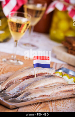 Traditional Dutch pickled herring with onions and mustard seed on a dish isolated on white ...