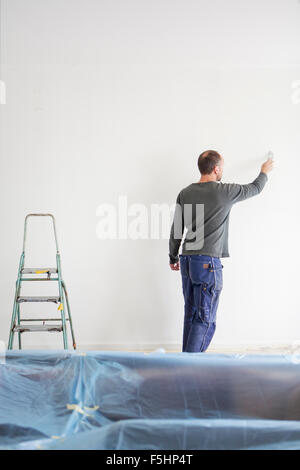 Man painting wall Stock Photo - Alamy