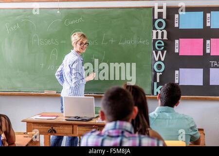 Female teacher addressing students in classroom Stock Photo - Alamy