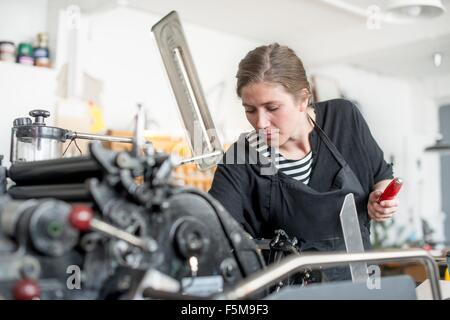 Woman using printer while working in print shop Stock Photo - Alamy