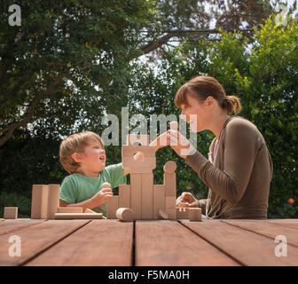 Child playing with wooden building blocks. Kid trial and error play ...