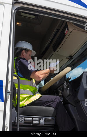 A lorry driver in safety clothing standing beside his vehicle Stock ...