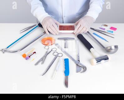 Pathologist about to perform a autopsy with his surgical equipment and ...