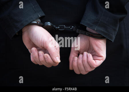 Woman with hands handcuffed behind back Stock Photo - Alamy