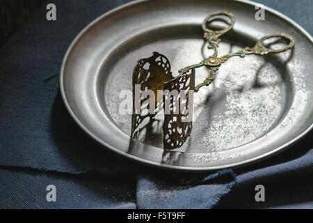 Plate and vintage cake tongs Stock Photo - Alamy