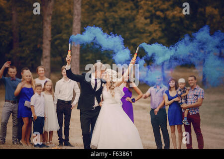 Wedding couple runs blue smoke Stock Photo - Alamy