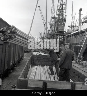 London docks, England, 1950s. Workers loading large sacks of raw ...