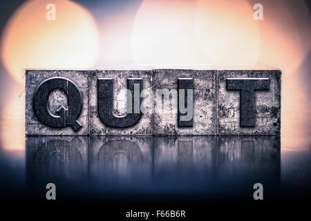 The word "Quit" written in vintage metal letterpress type isolated on a ...