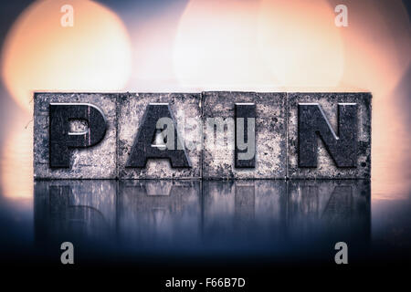 The word "Pain" written in vintage metal letterpress type isolated on a ...