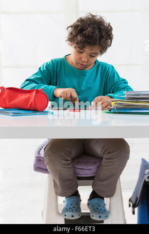 Young hispanic kid doing homework sitting on the sofa crazy and scared ...