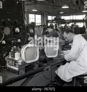 1950s, historical, white coated engineer working on an electrical ...