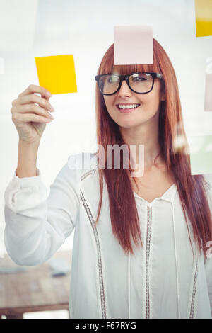 Attractive hipster woman looking at sticky notes Stock Photo - Alamy