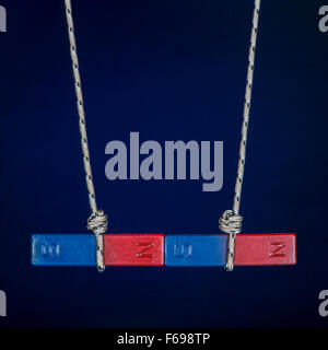 Two magnets repelling each other with one magnet hovering above the ...