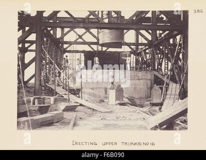 A photograph showing the construction of a railroad bridge near a dock ...
