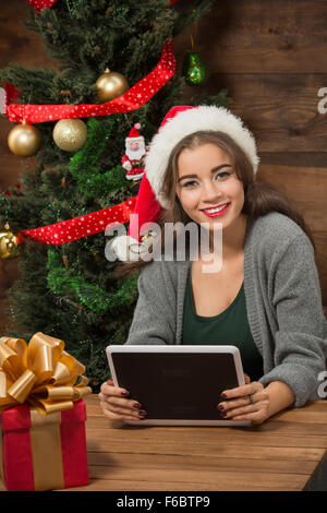 Beautiful girl holding a present near New Year tree Stock Photo - Alamy
