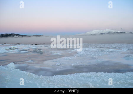 long icy sea with thick ice fog and mist with colorful dawn sky on very ...